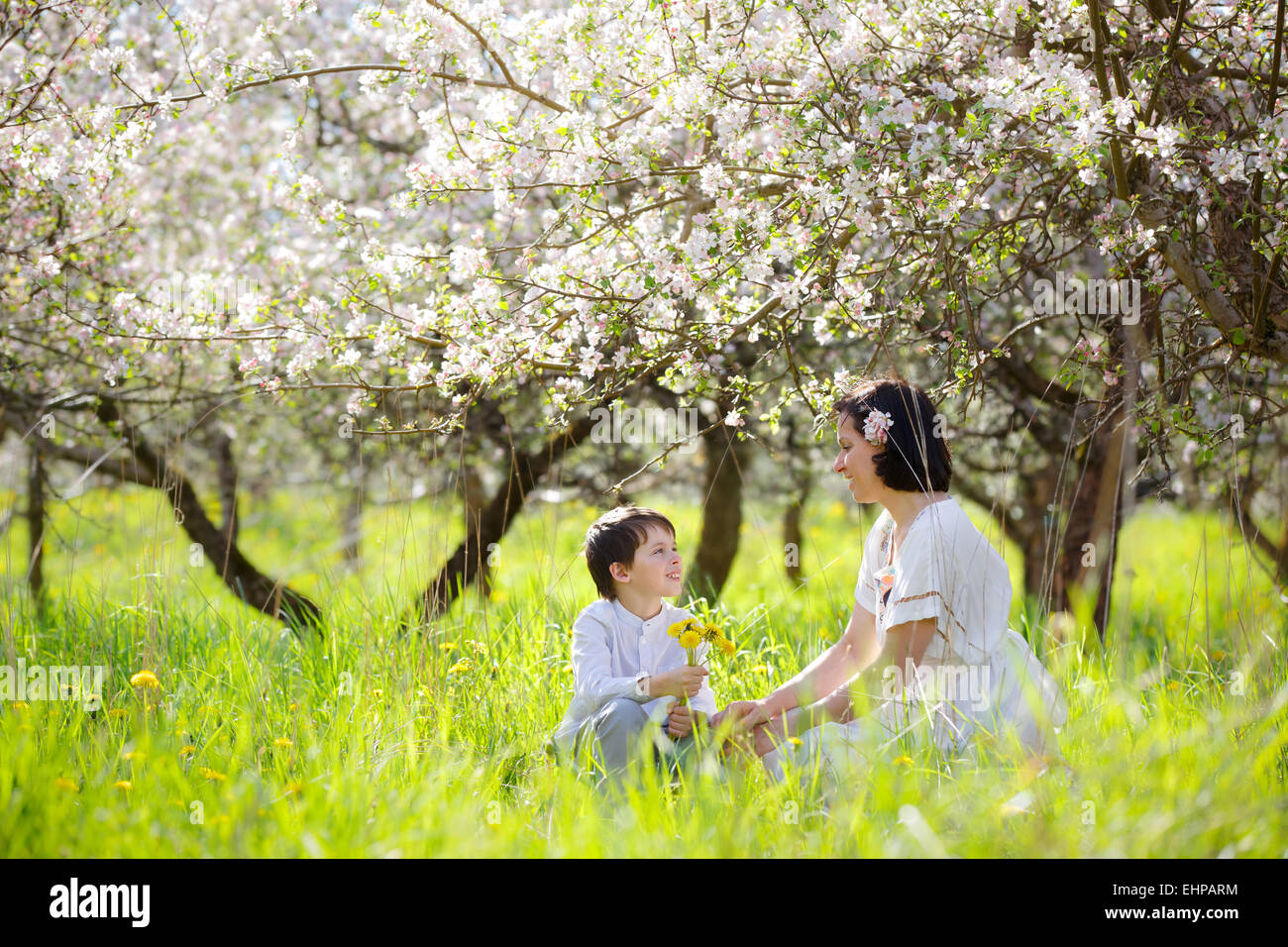 Young woman and her child in spring apple garden Stock Photo - Alamy