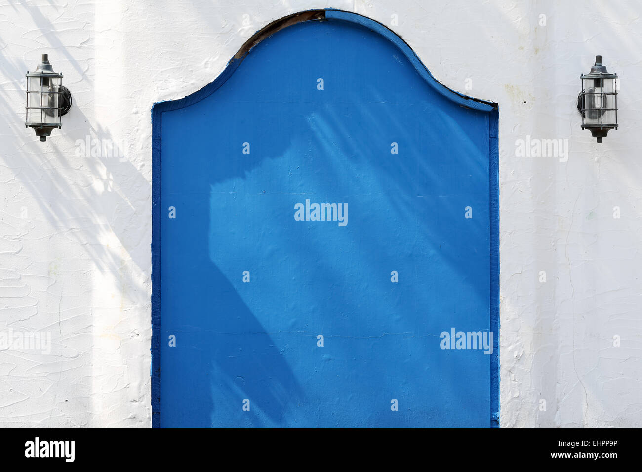 Old metal blue gateway with white wall Stock Photo - Alamy