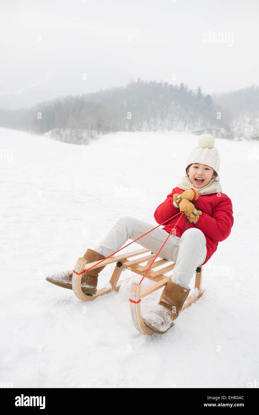 Happy girl sliding on a sled Stock Photo - Alamy