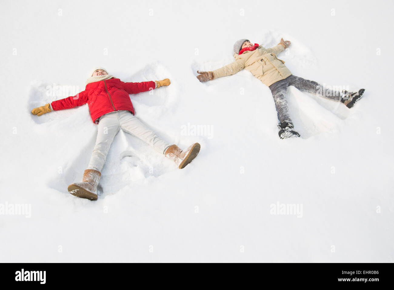 Two children making snow angels Stock Photo - Alamy