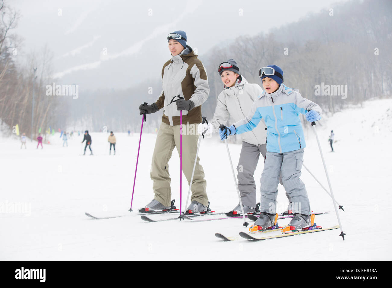 Young family skiing in ski resort Stock Photo - Alamy
