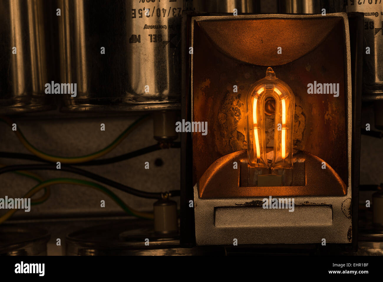 glowing filament of a 1000 quartz halogen bulb with flaked metal and ...