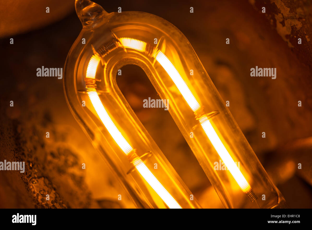 glowing filament of a 1000 quartz halogen bulb with flaked metal and ...