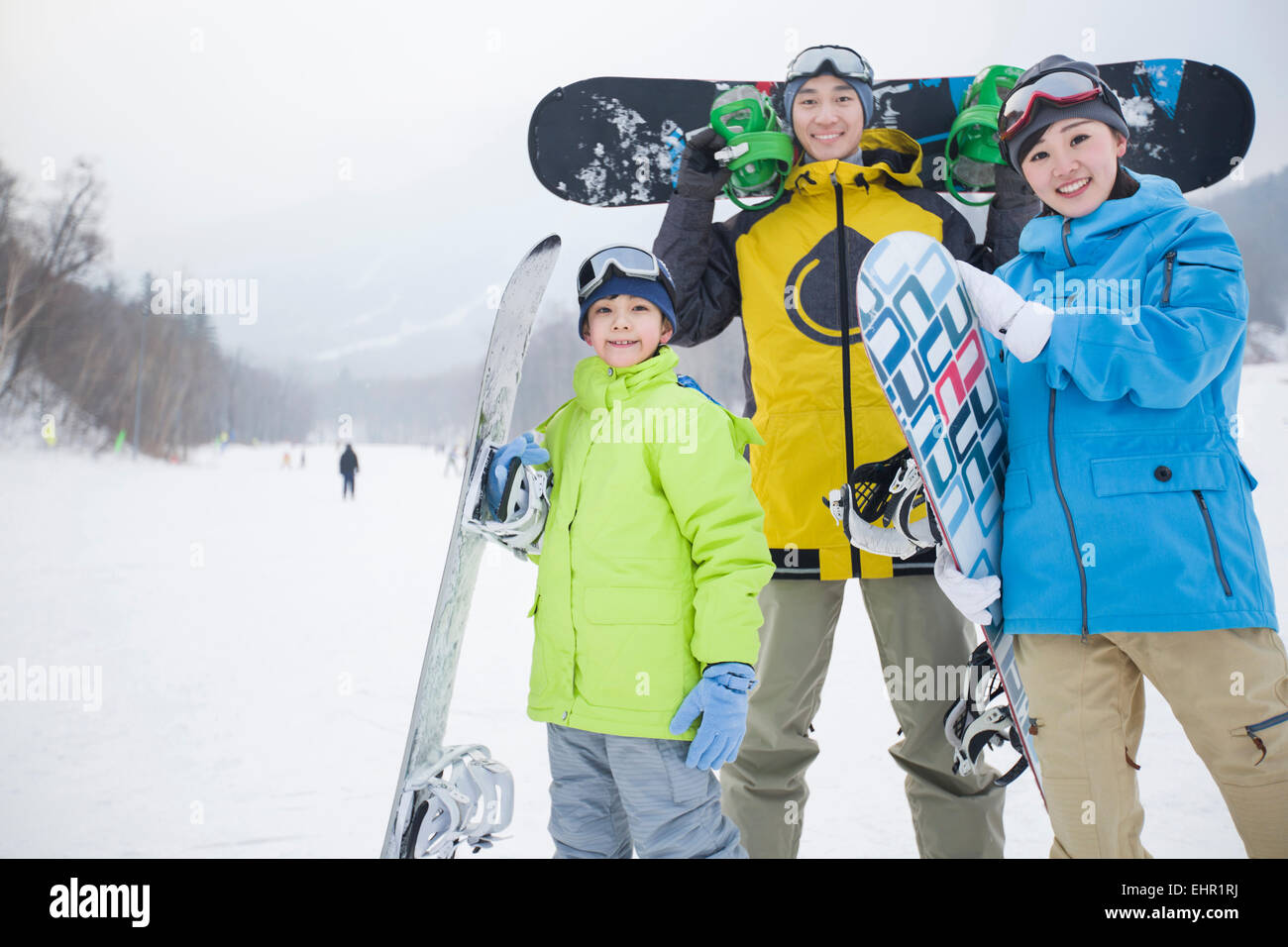 Young family with snowboards on the snow Stock Photo - Alamy