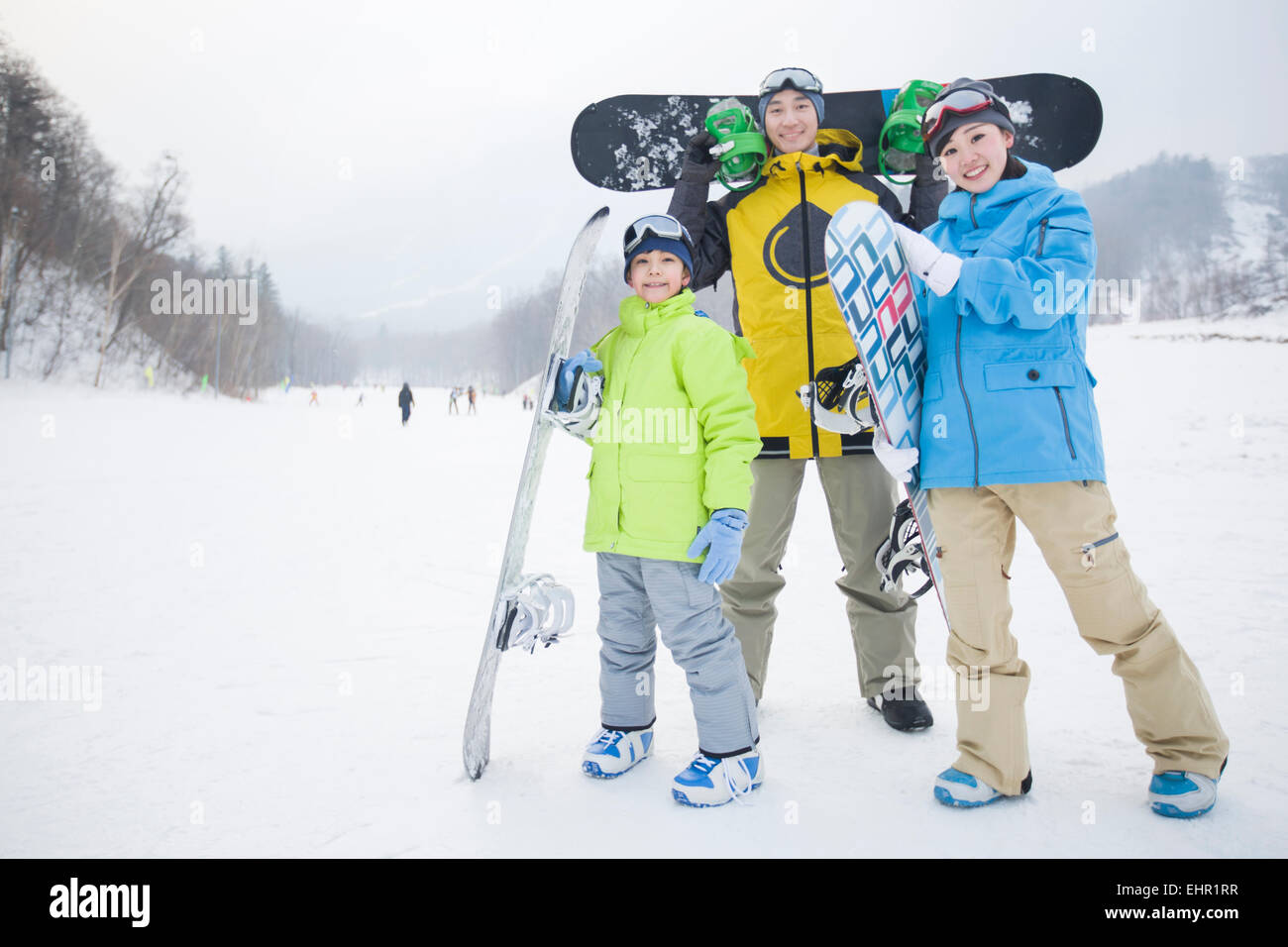 Young family with snowboards on the snow Stock Photo - Alamy