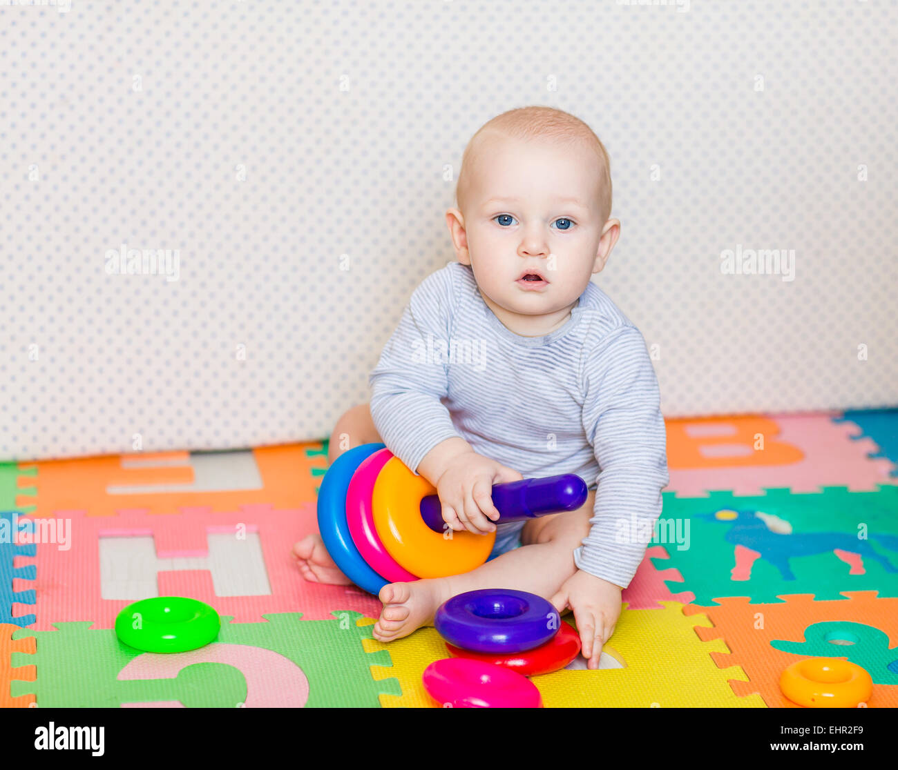 Cute little baby playing with colorful toys at home Stock Photo - Alamy
