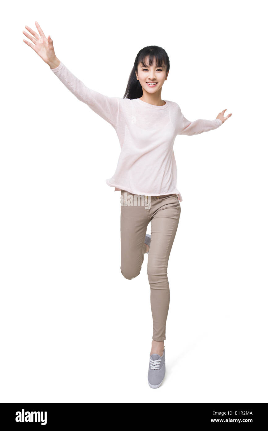 Happy young woman standing on one leg Stock Photo - Alamy