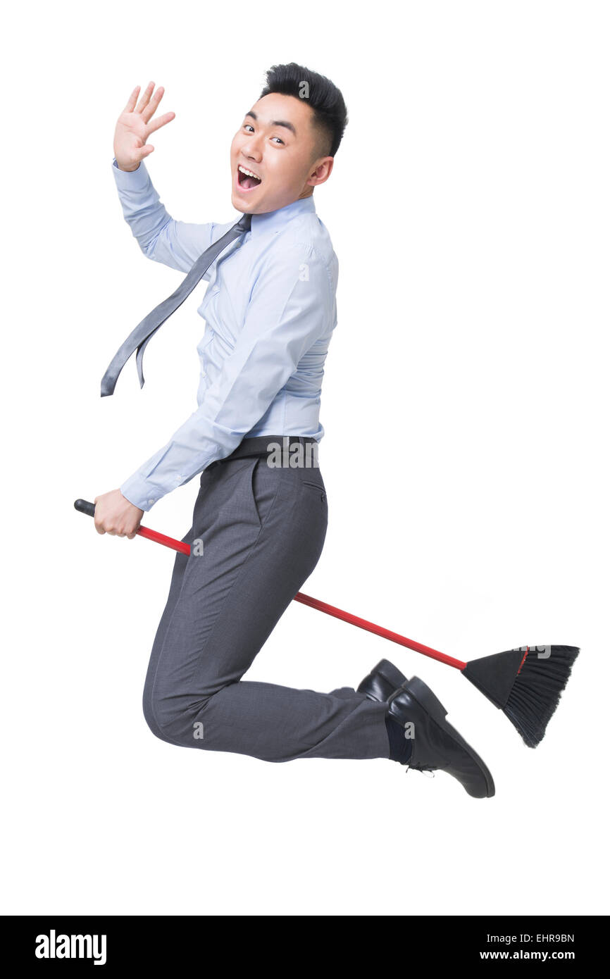 Young businessman flying on broom Stock Photo - Alamy