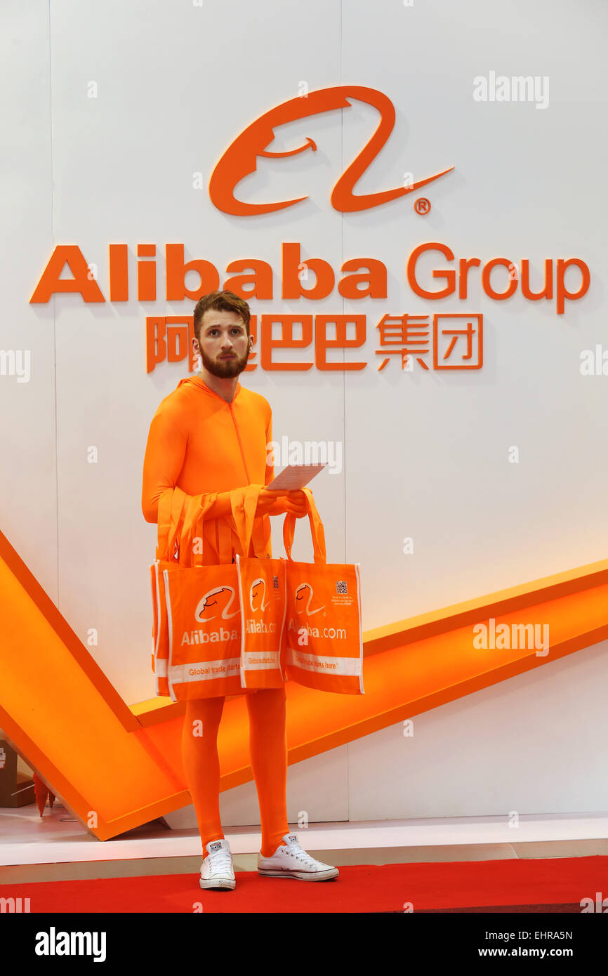 A stand host offers promotion material at the booth of Alibaba Group ...
