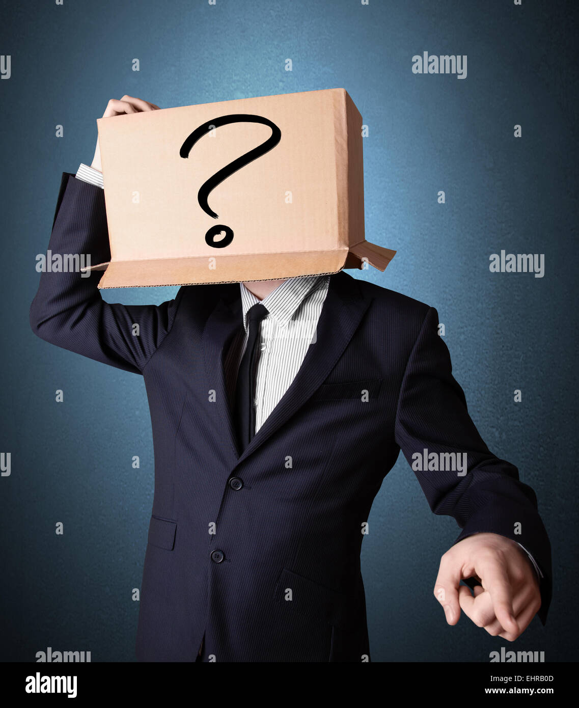 Businessman gesturing with a cardboard box on his head with question ...