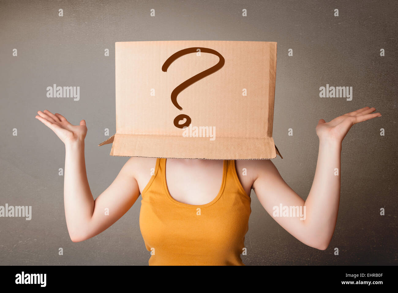 Young lady gesturing with a cardboard box on her head with question ...