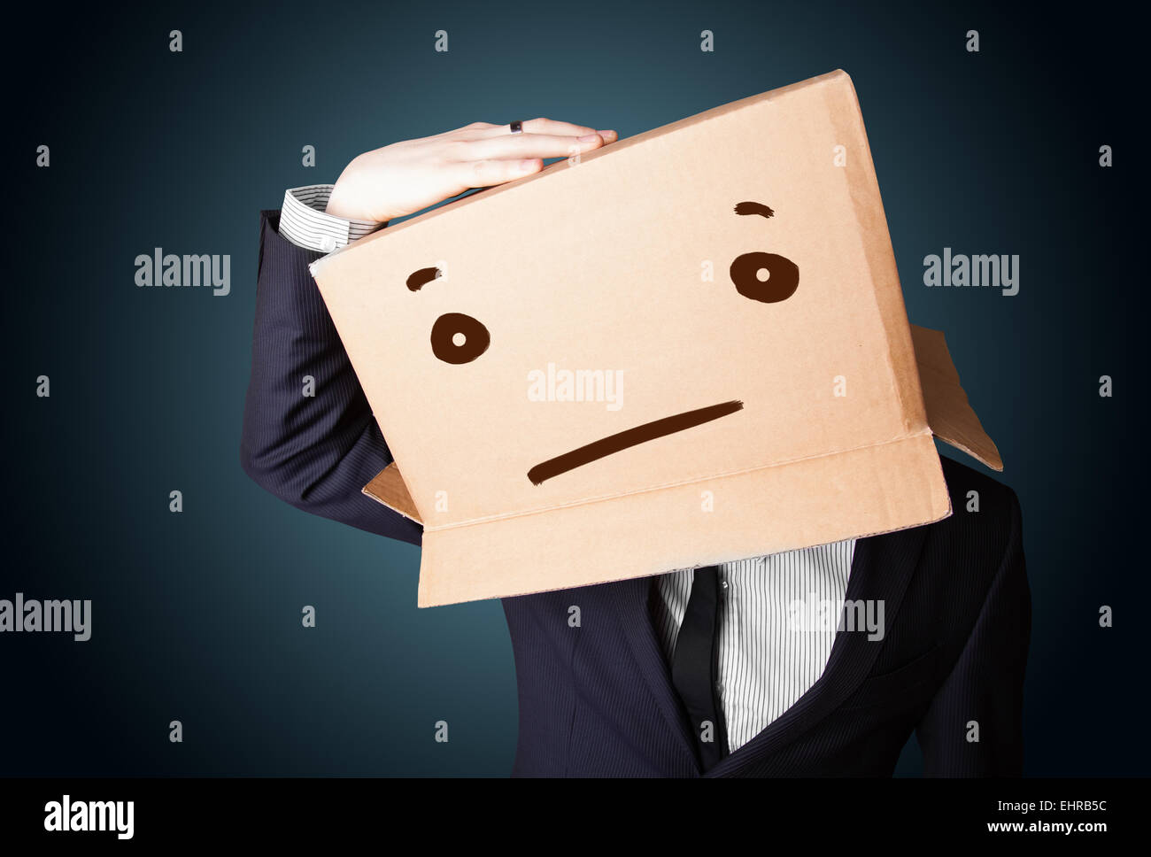 Businessman gesturing with a cardboard box on his head with straight ...