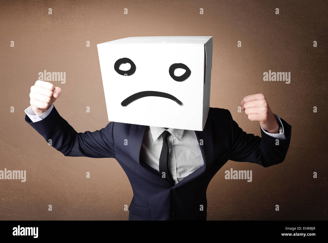 Businessman gesturing with cardboard box on his head with sad face ...