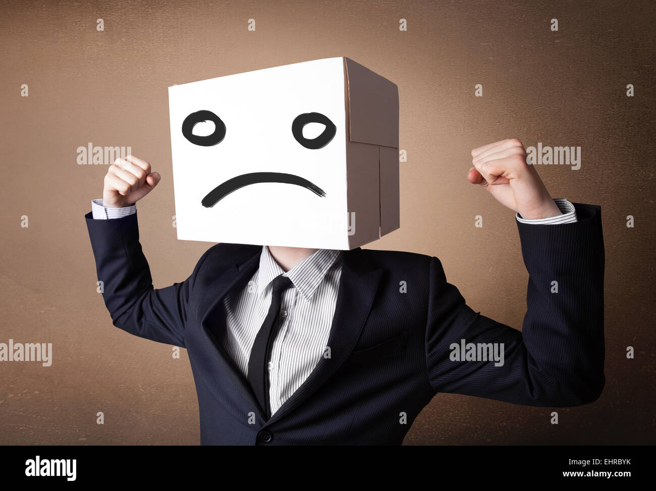 Businessman gesturing with cardboard box on his head with sad face ...