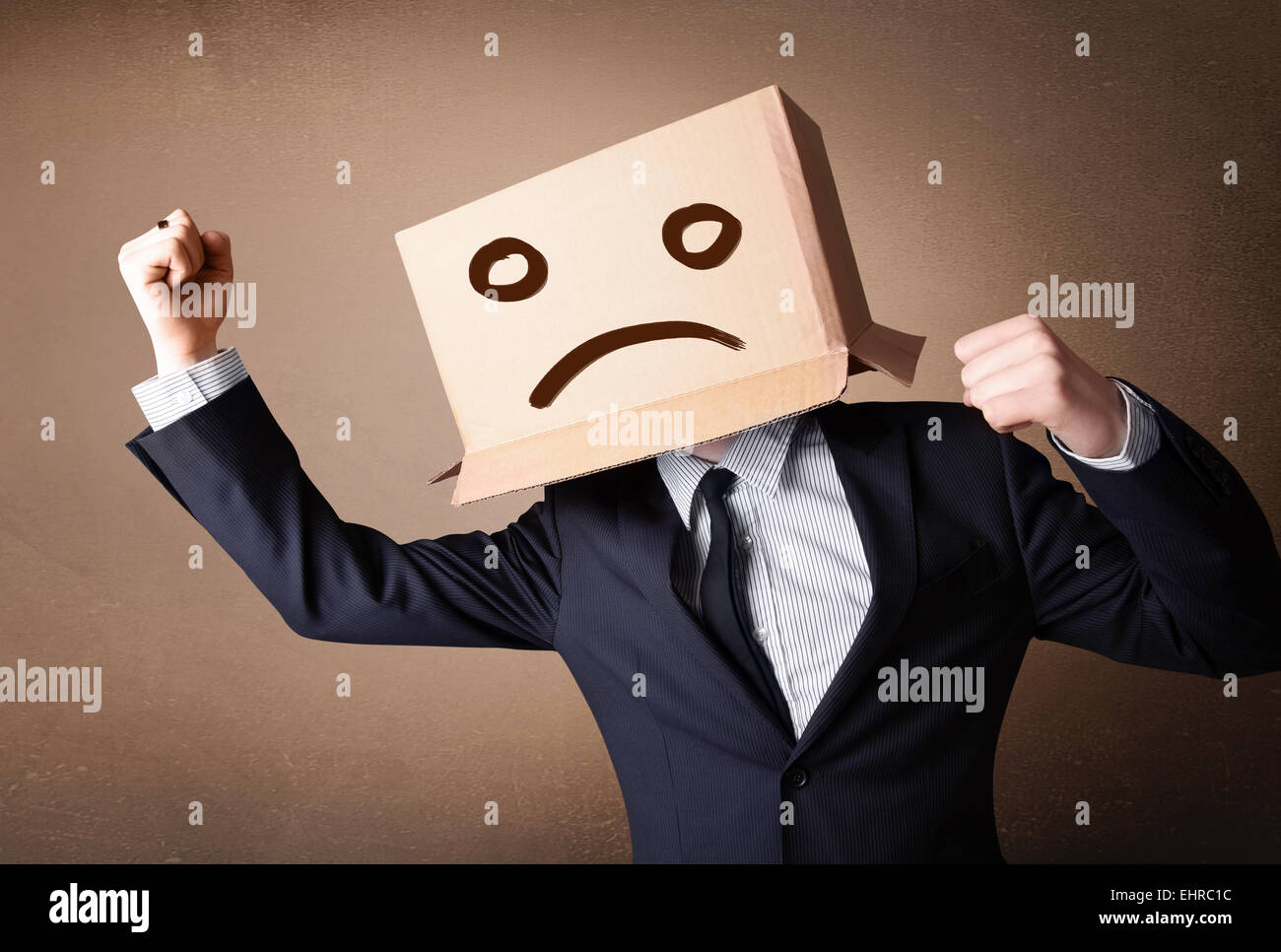 Businessman gesturing with cardboard box on his head with sad face ...