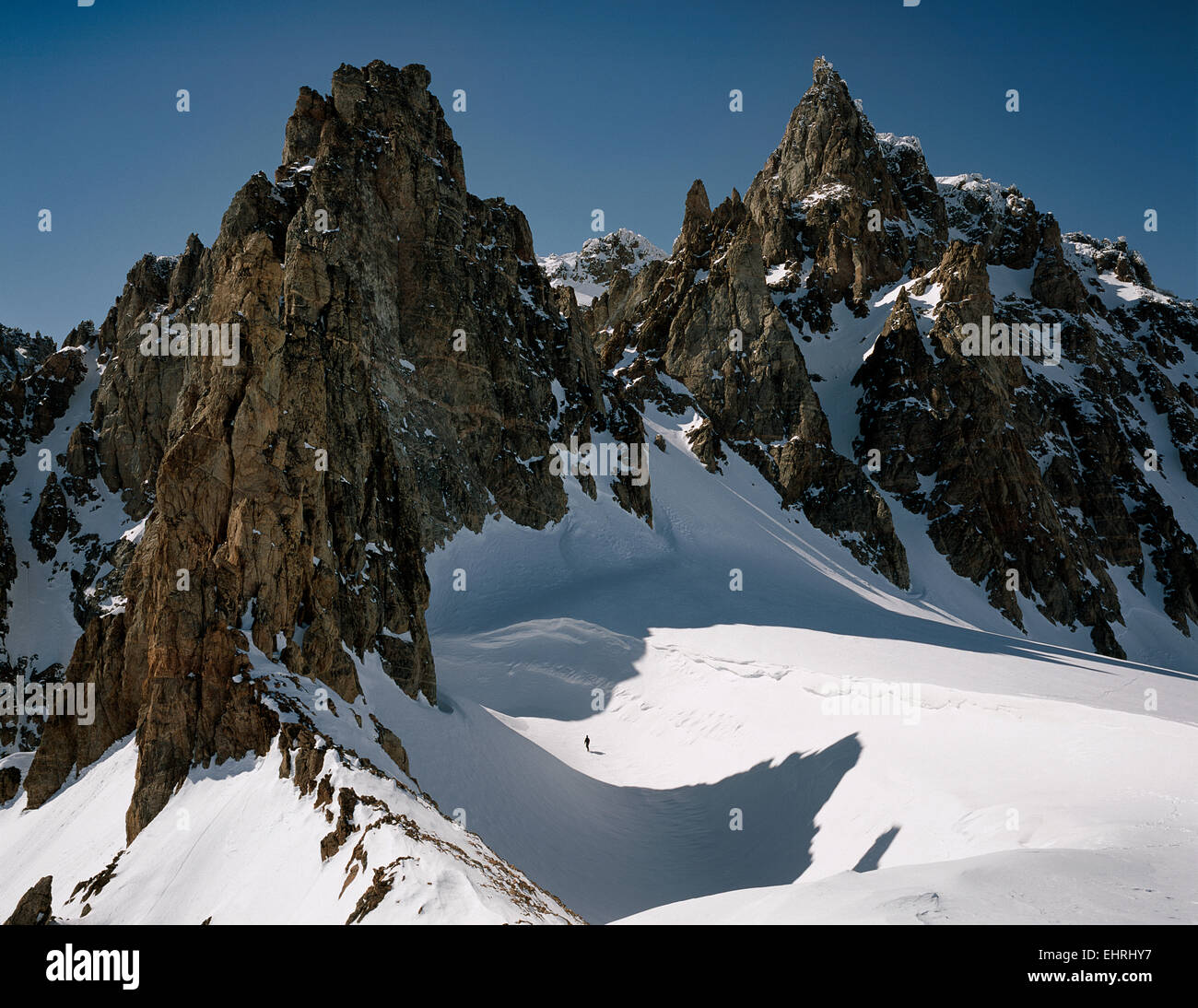 Single figure walks in snow among rock outcrops at Age Nielsen Glacier ...