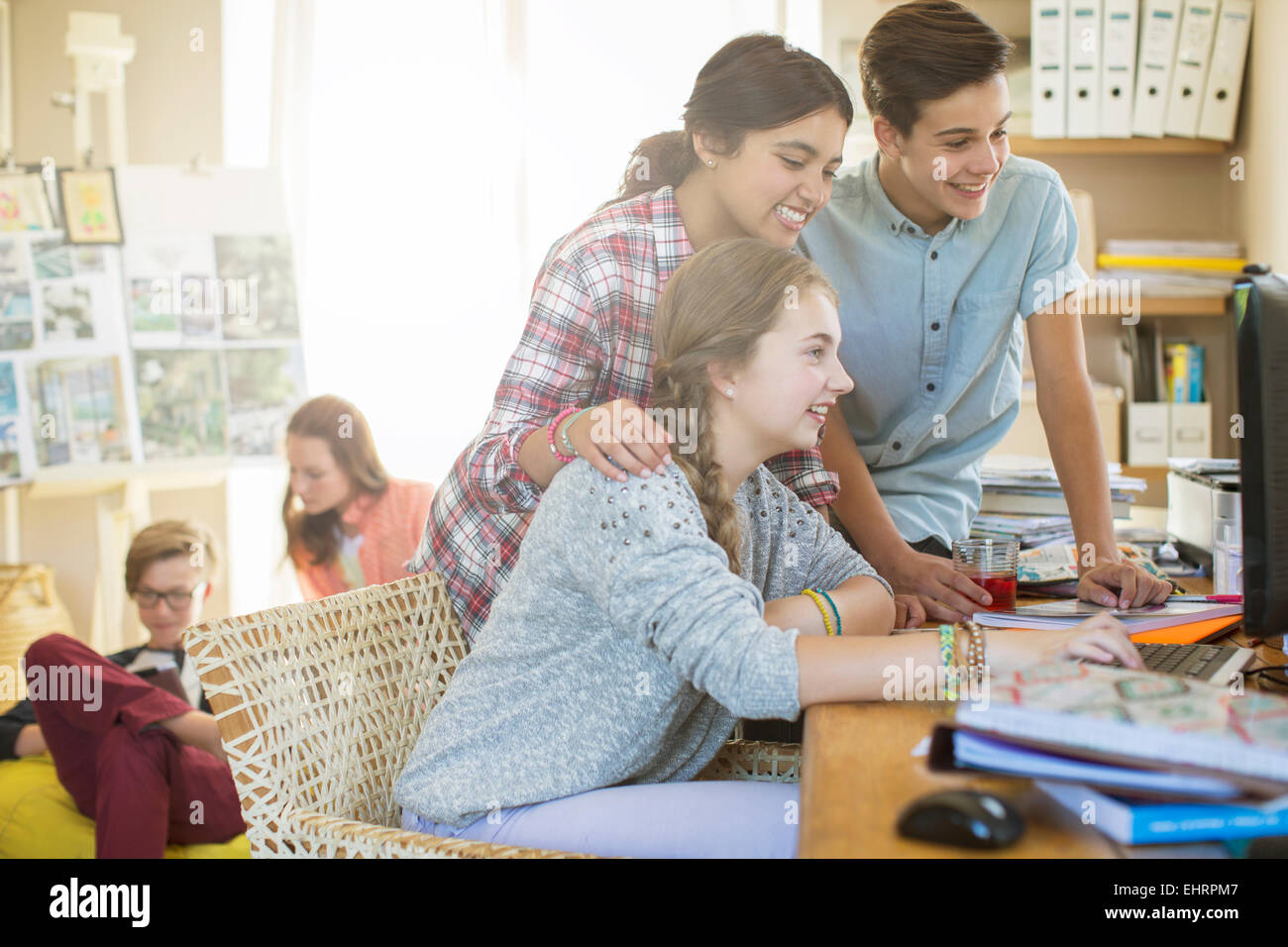 Teenagers sharing computer in living room Stock Photo - Alamy