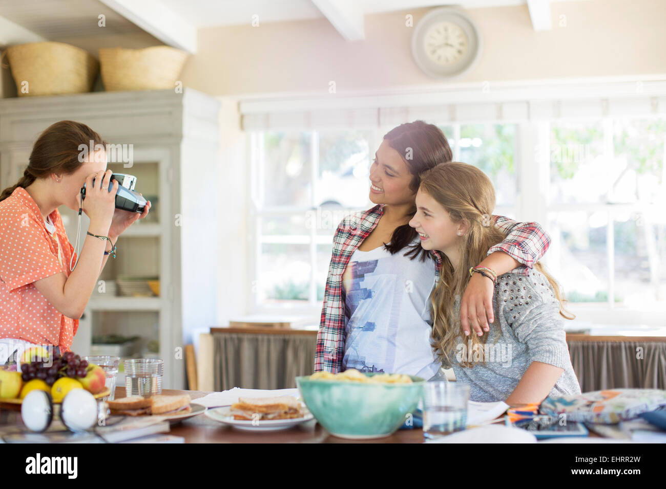 Teenage girls photographing themselves in dining room Stock Photo - Alamy