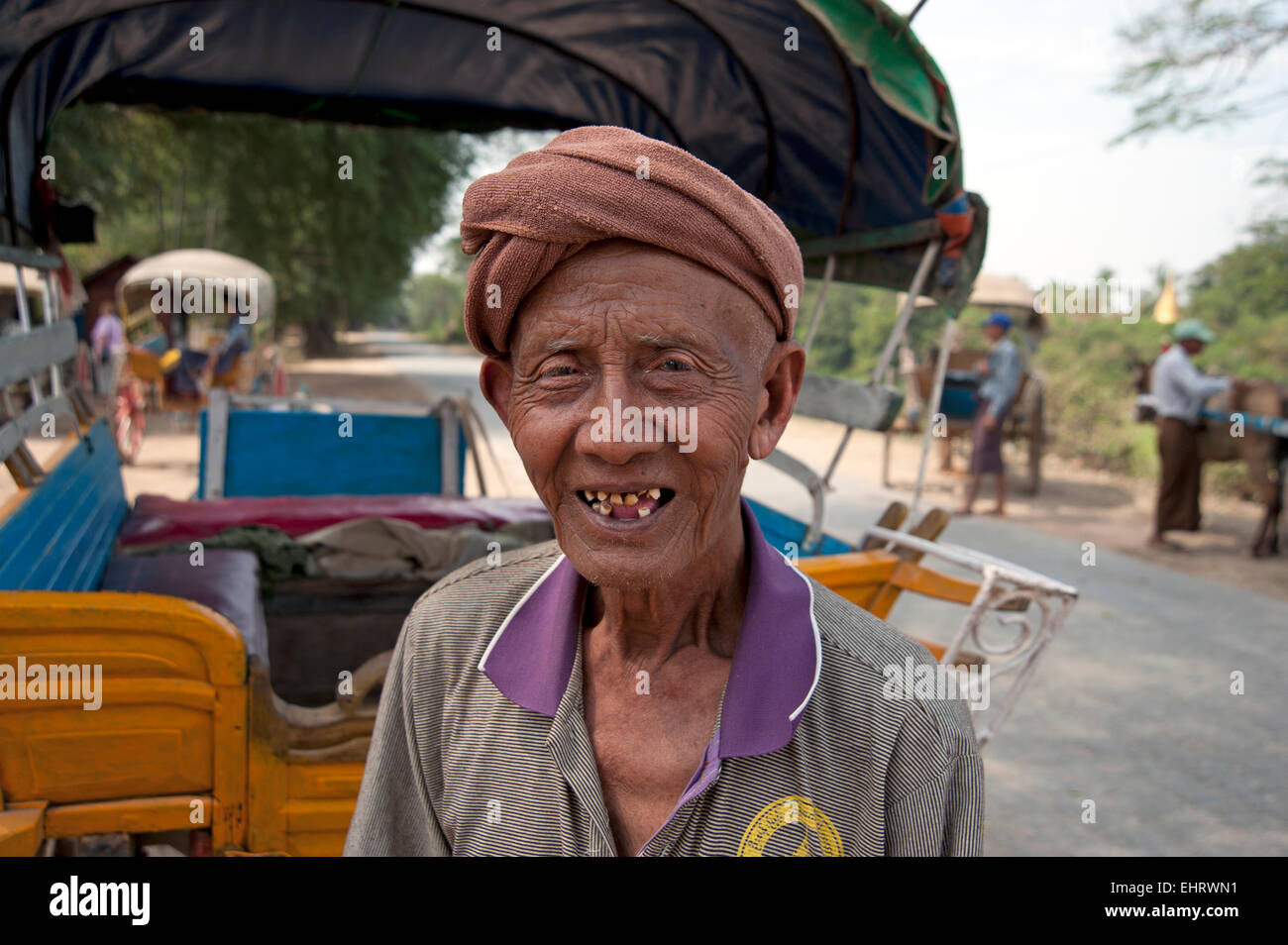 Old man horse and cart driver stands by his cart in the ancient ruined ...