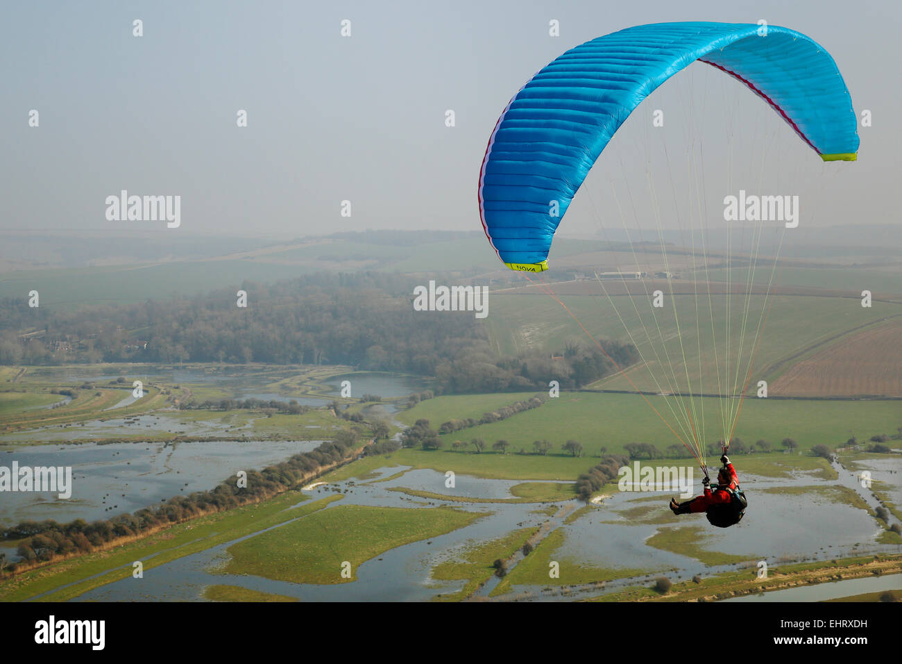A man flies a paraglider over flood plains of the Cuckmere Valley in ...