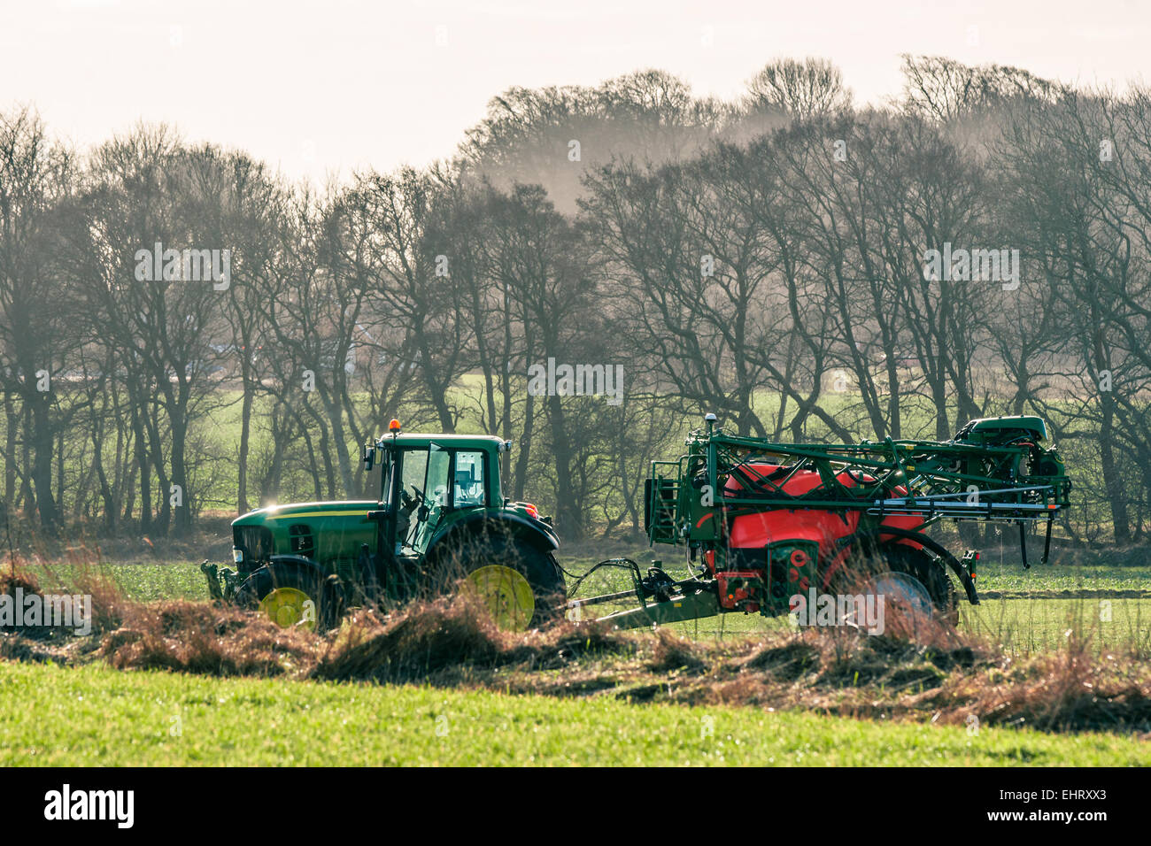 Tractor driving on a field with fertilizer in early spring Stock Photo ...