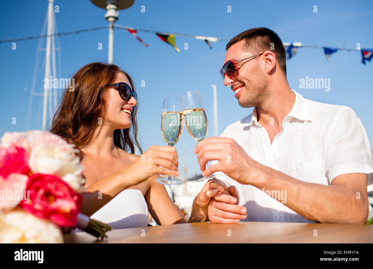 smiling couple drinking champagne at cafe Stock Photo - Alamy