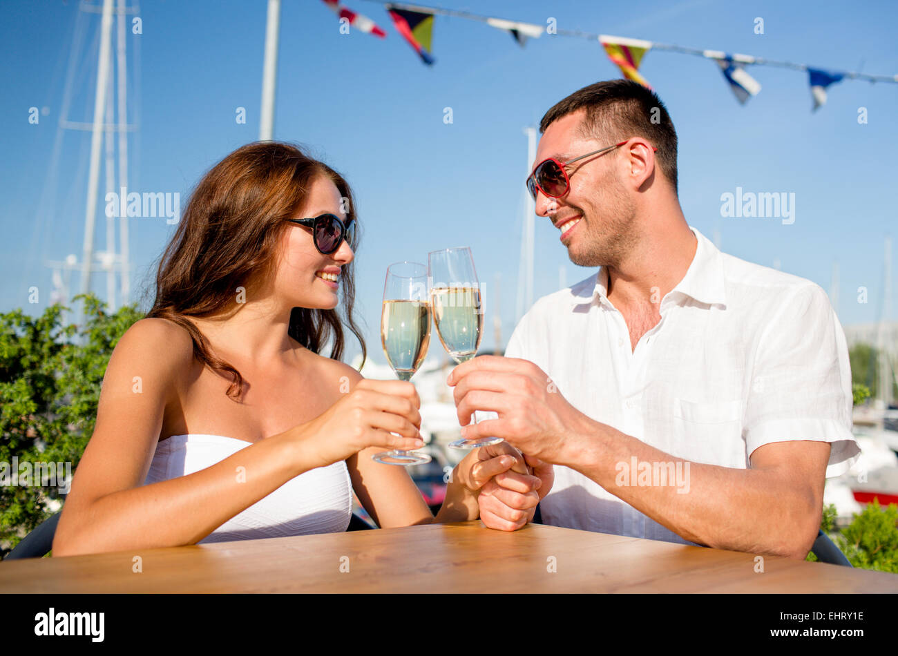 smiling couple drinking champagne at cafe Stock Photo - Alamy