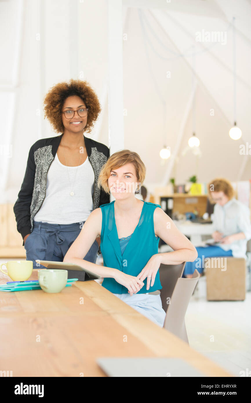 Portrait of two smiling office workers at desk Stock Photo - Alamy