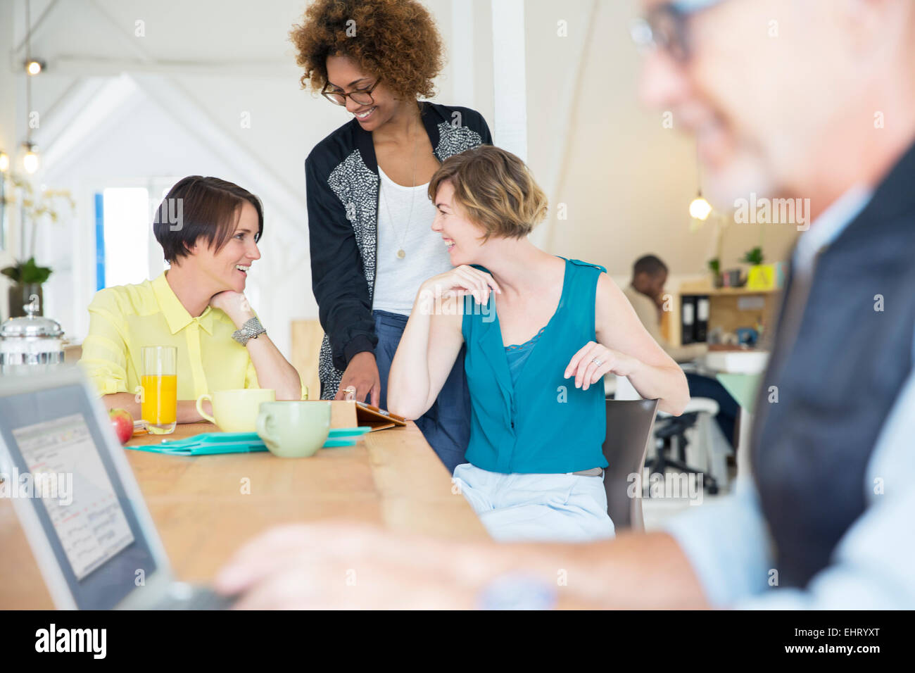 Smiling office workers talking at desk during break Stock Photo - Alamy