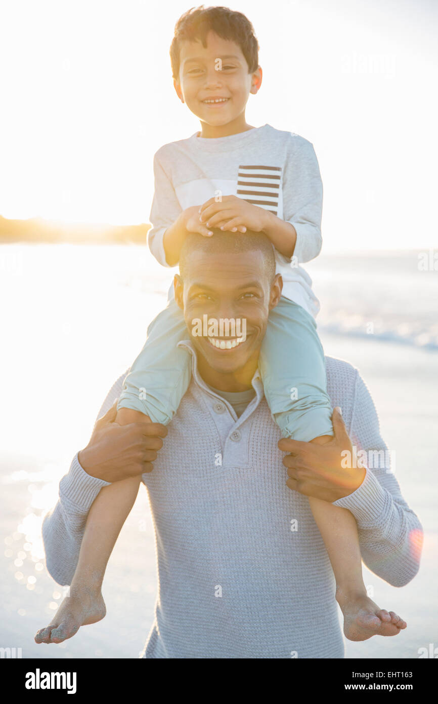 Portrait of father carrying son on shoulders and smiling Stock Photo ...