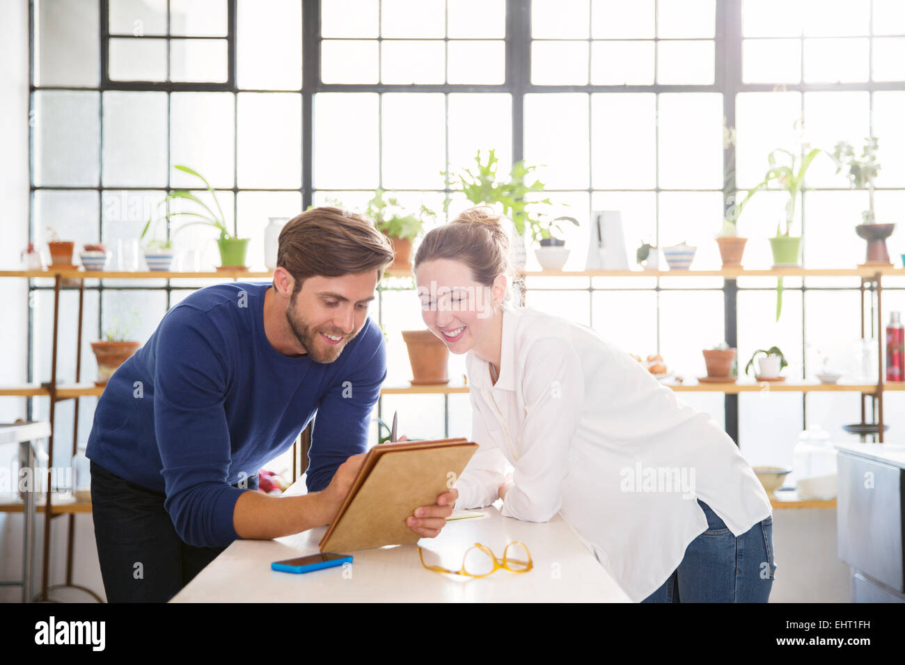 Two young people looking at documents in domestic kitchen Stock Photo ...