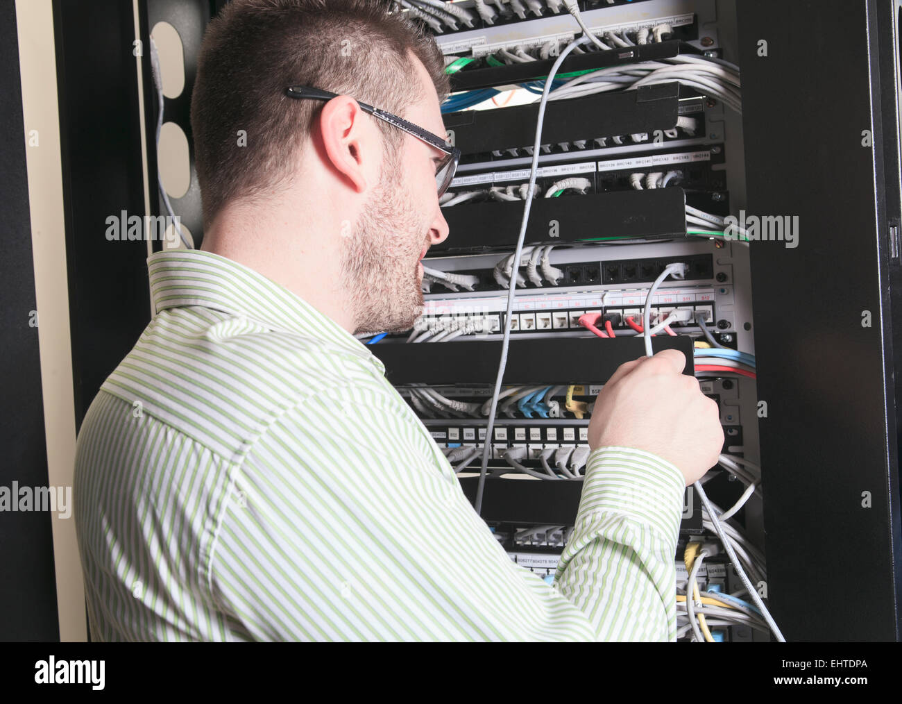 Network engineer working in server room Stock Photo - Alamy