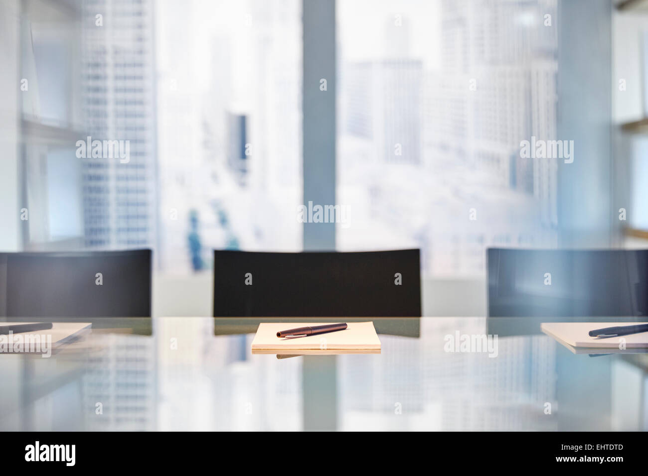 Part of modern conference room with table chairs, notepads and pens ...