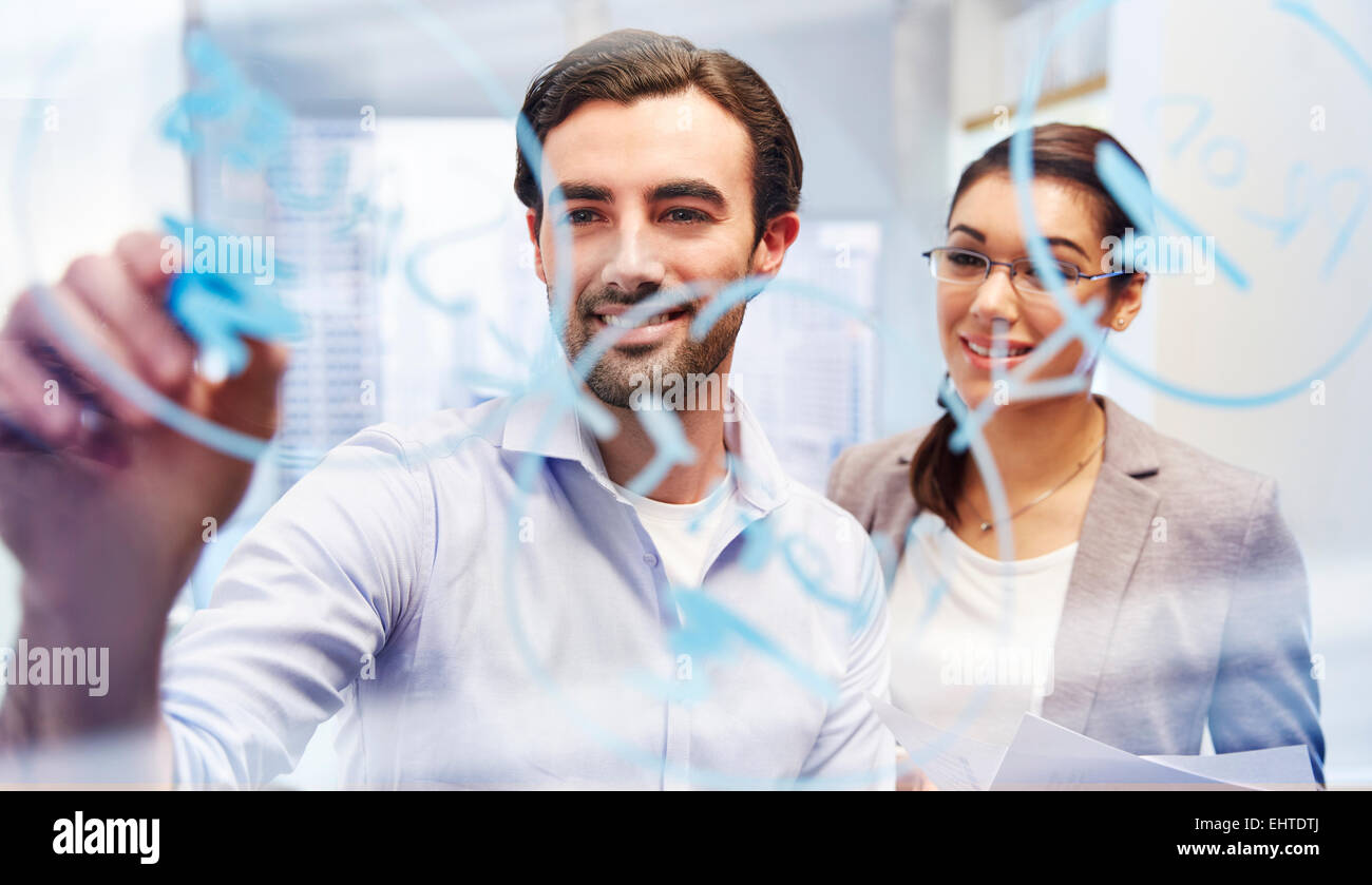 Office workers behind glass with blue marker writing on it Stock Photo ...