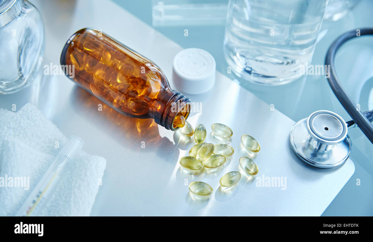 Flask with capsules and stethoscope on desk Stock Photo - Alamy
