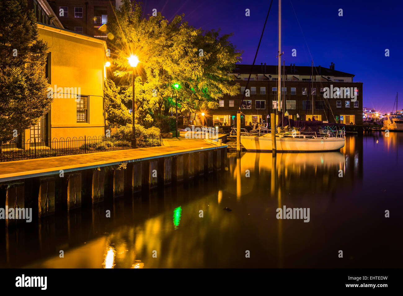 Boat and waterfront promenade in Fells Point at night, Baltimore ...