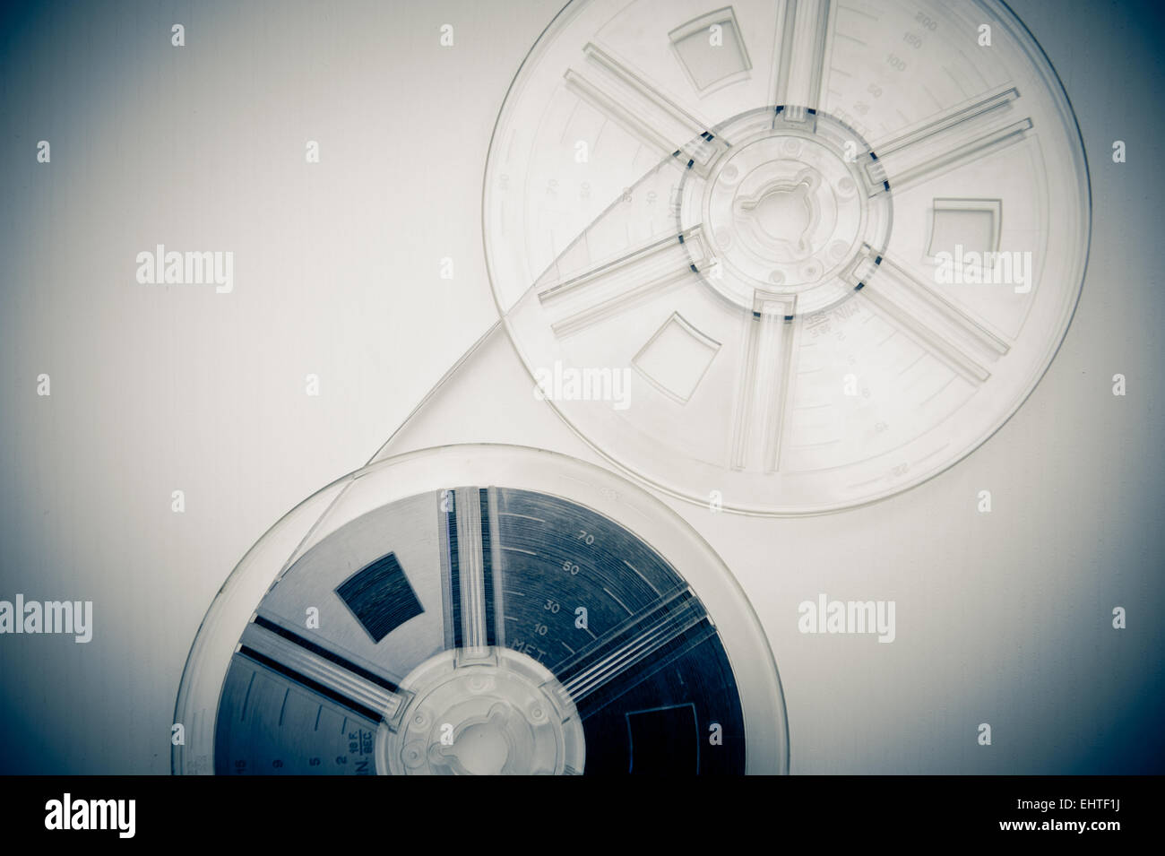 Two transparent 8mm movie reels connected with film in vintage color ...