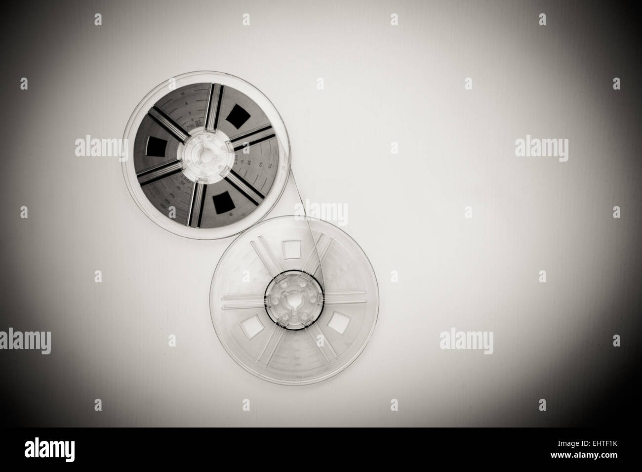 Two vintage transparent 8mm movie reels connected with film sepia black ...