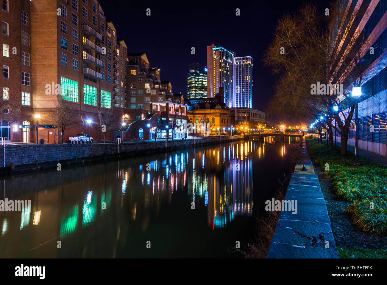 Buildings reflecting in the water at night in the Inner Harbor of ...