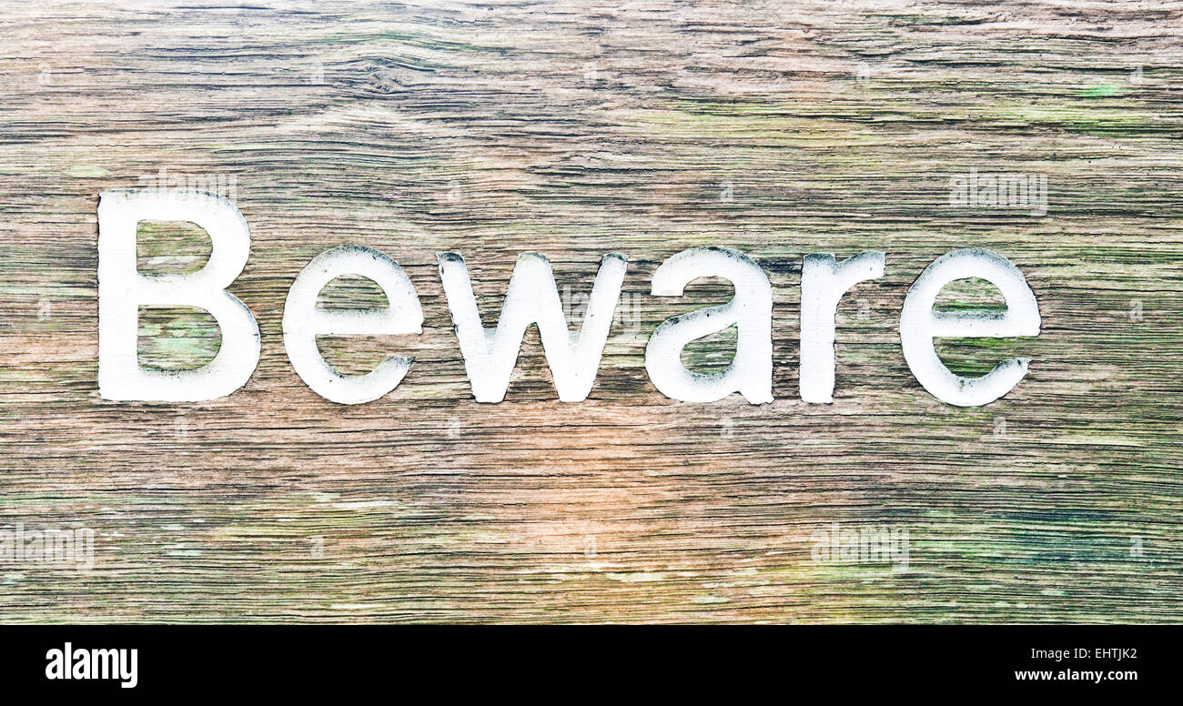 A wooden sign with beware written on it Stock Photo - Alamy