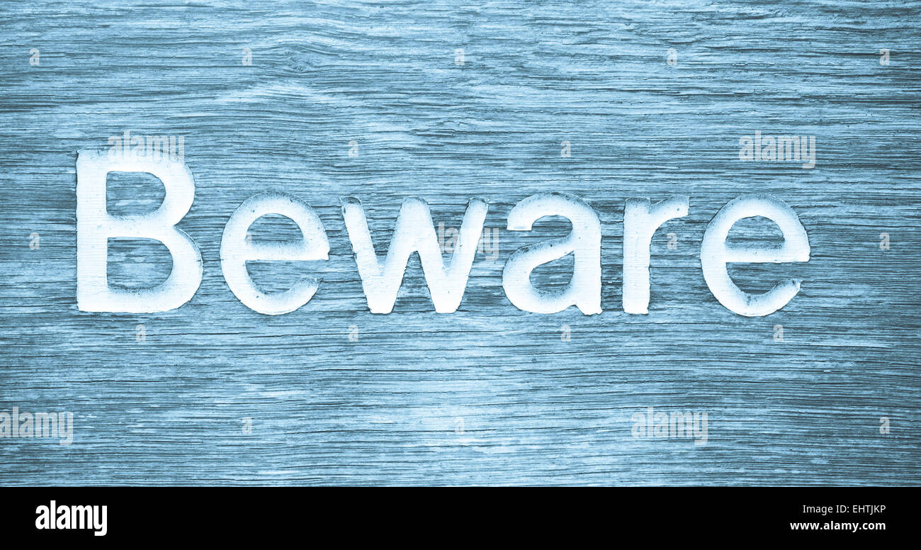 A wooden sign with beware written on it Stock Photo - Alamy