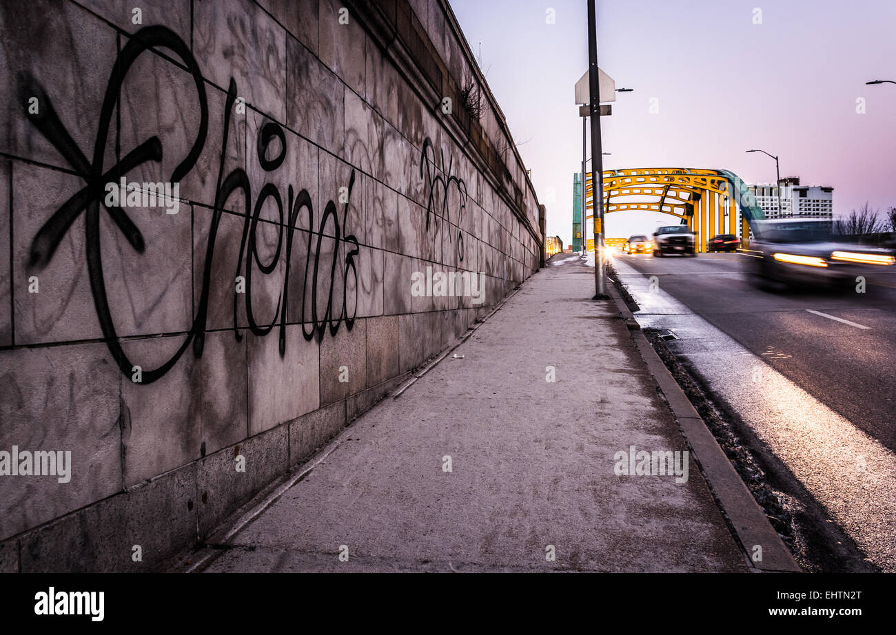 Graffiti on a wall and traffic moving over the Howard Street Bridge in ...