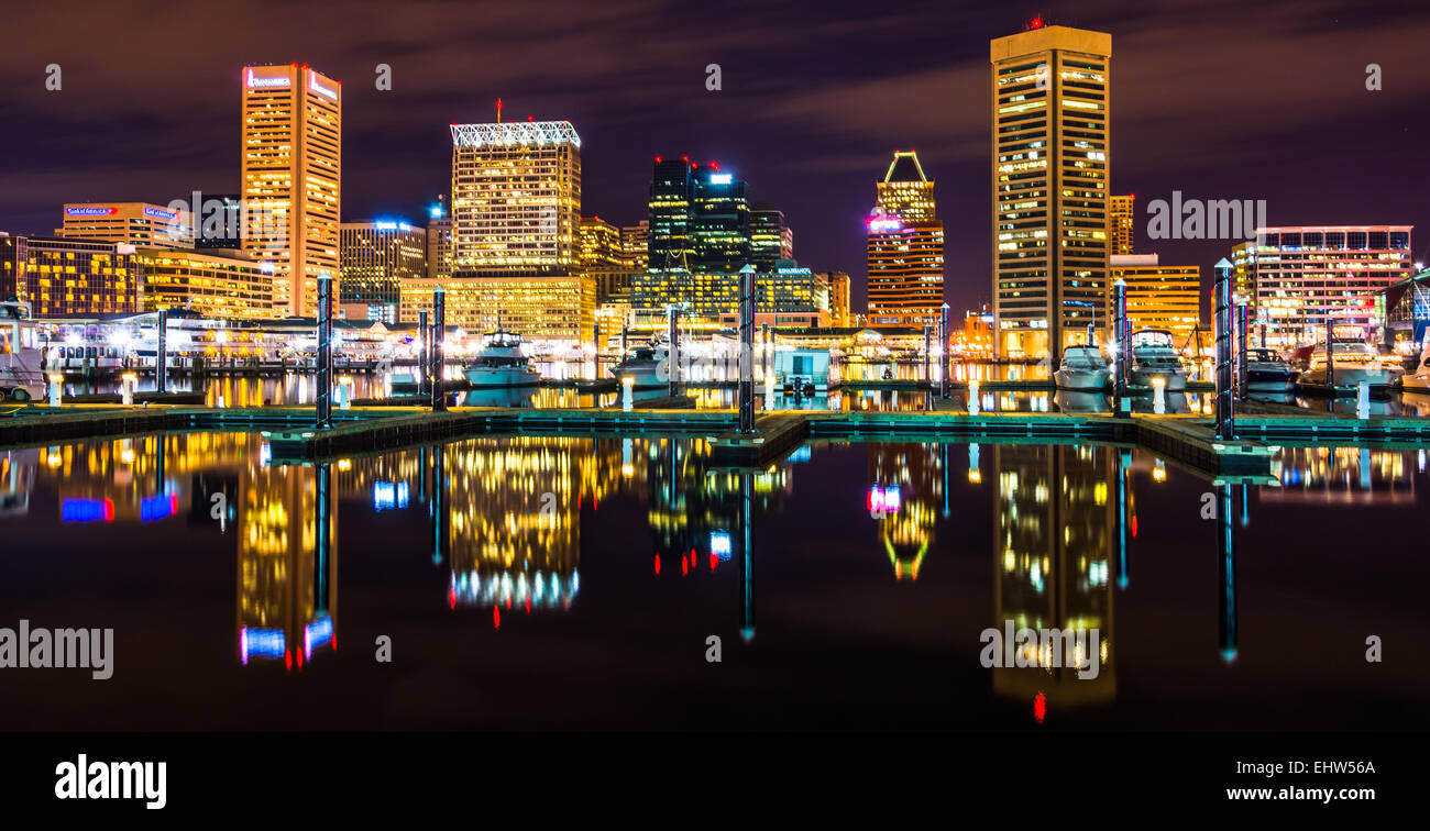 The skyline and docks reflecting in the water at night, in the Inner ...
