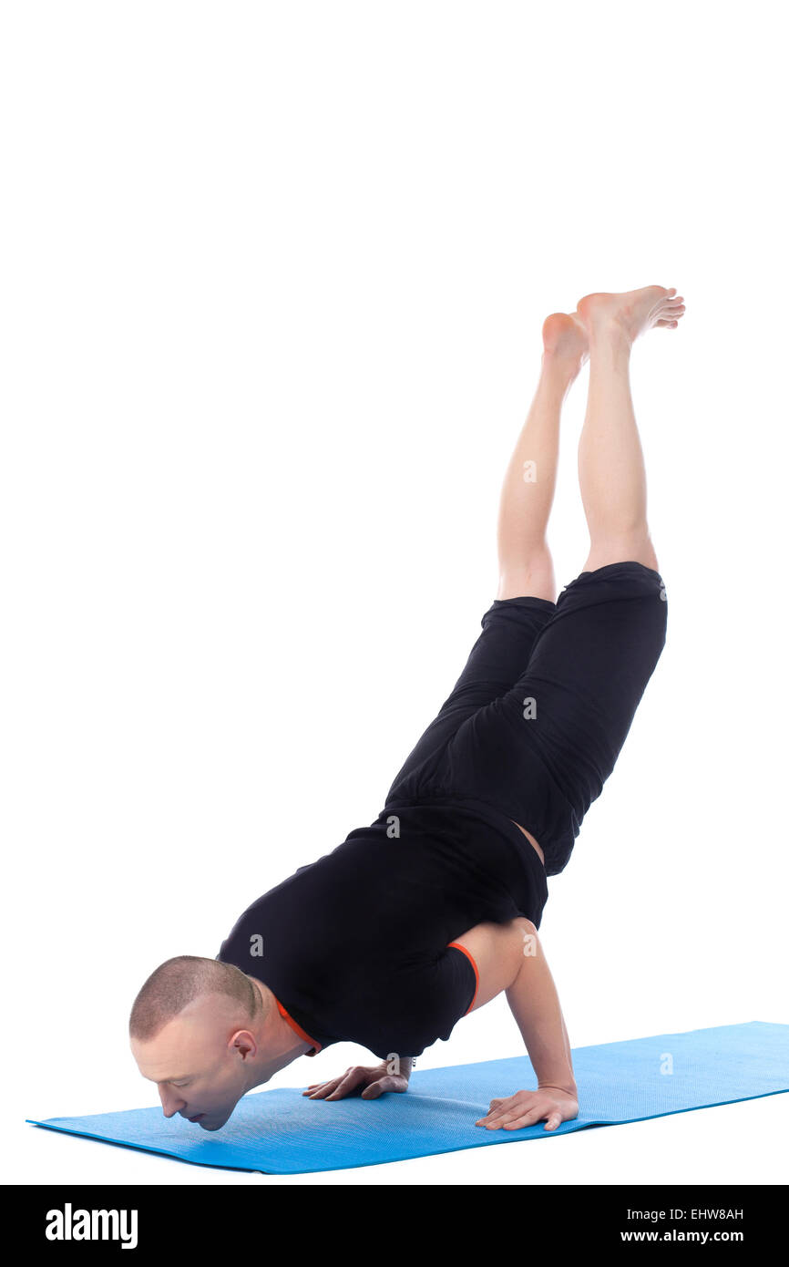 Athletic man doing yoga handstand in studio Stock Photo - Alamy