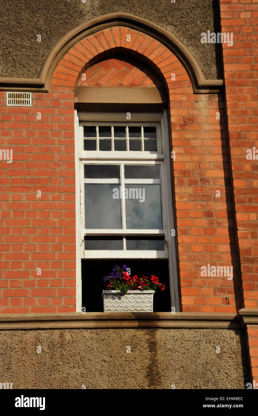 Arch above open window with flower box, building with decorative red ...