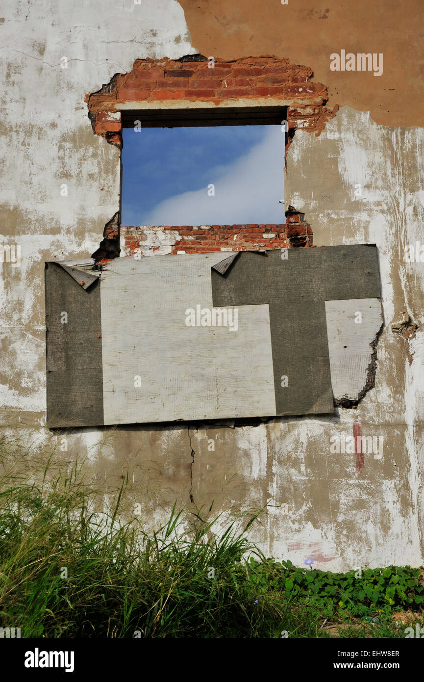 Window of derelict abandoned building covered with wooden board ...