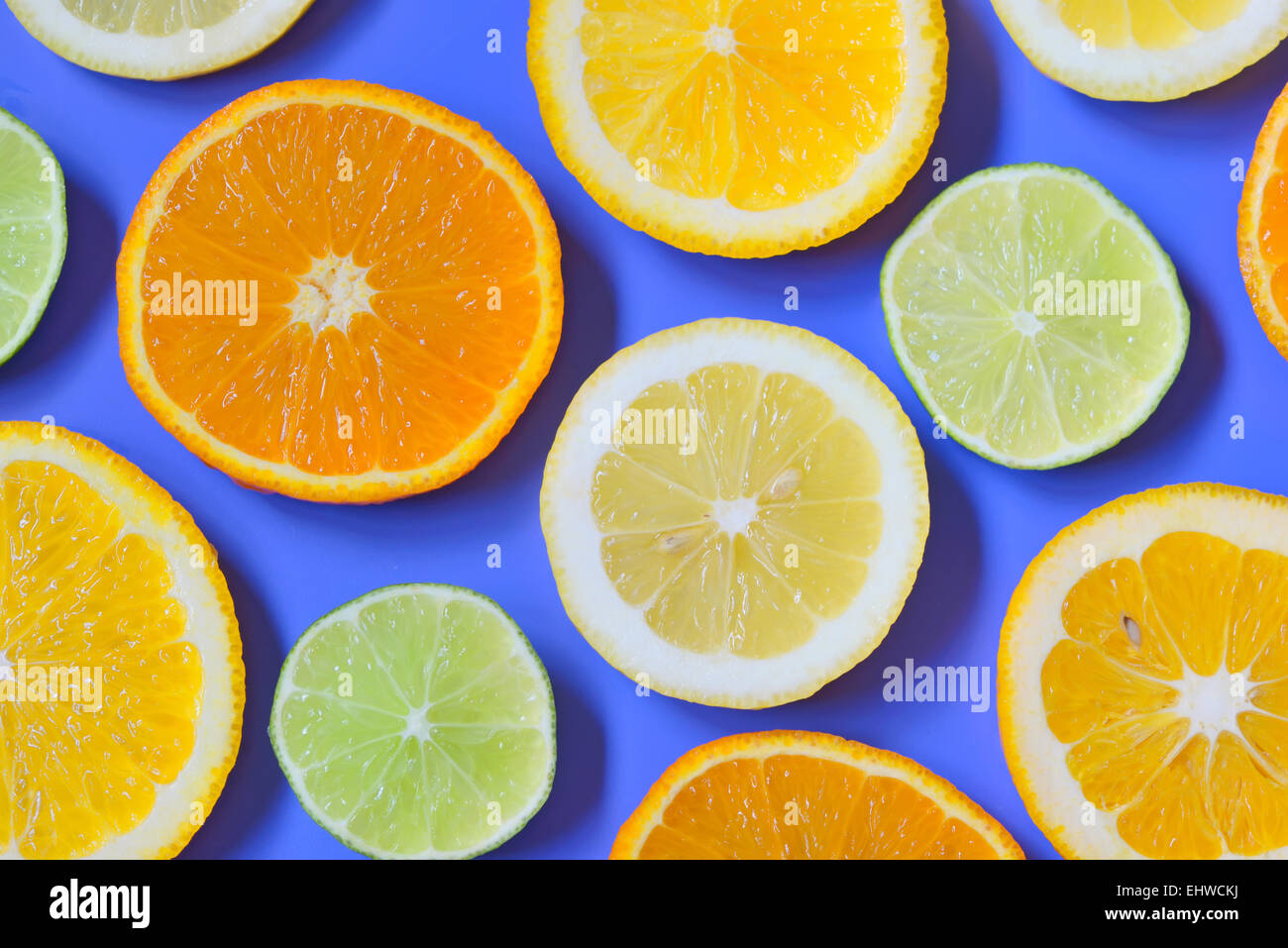 Slices of various citrus fruits on blue background Stock Photo - Alamy