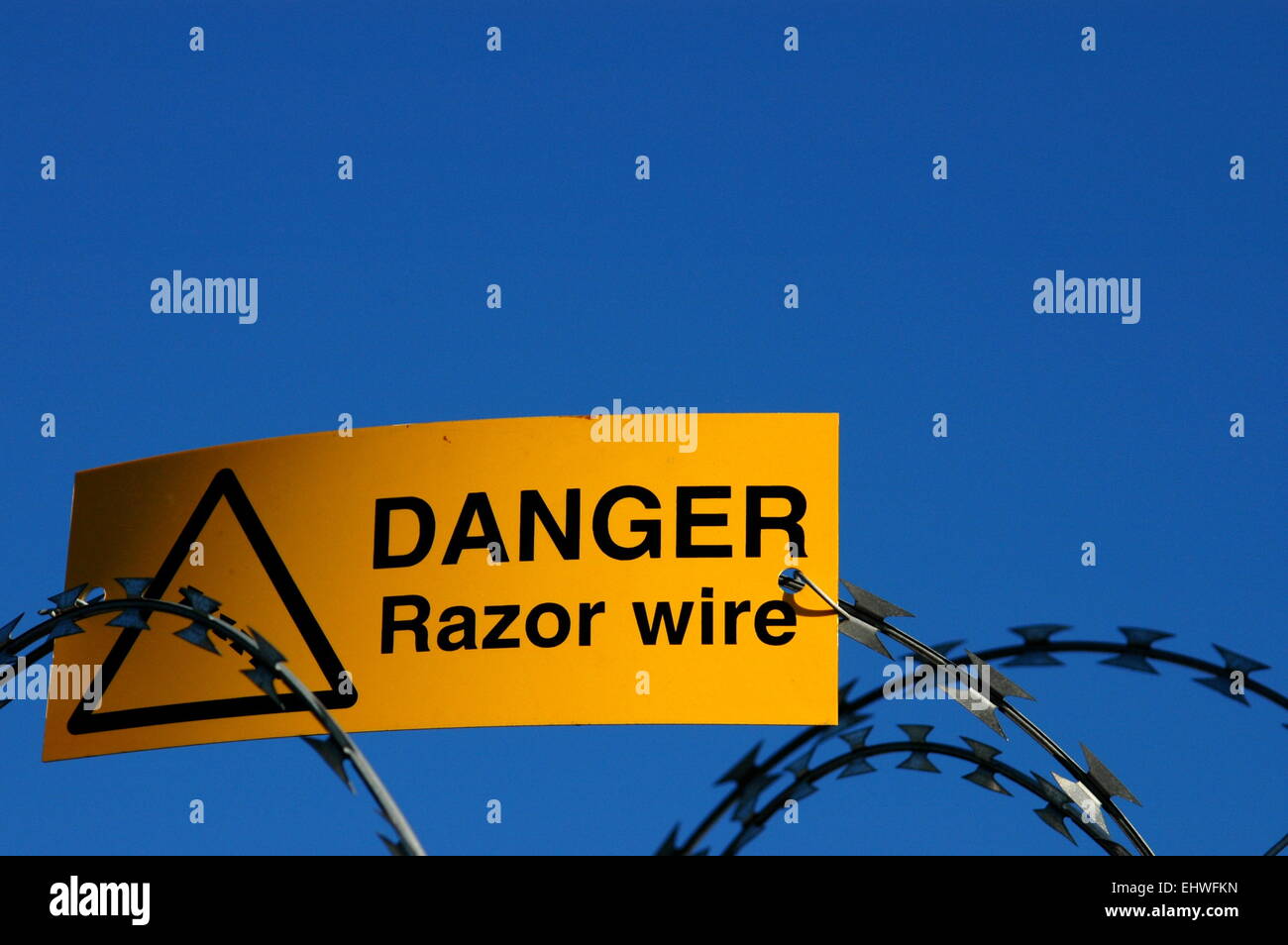 Yellow danger razor wire sign hi-res stock photography and images - Alamy