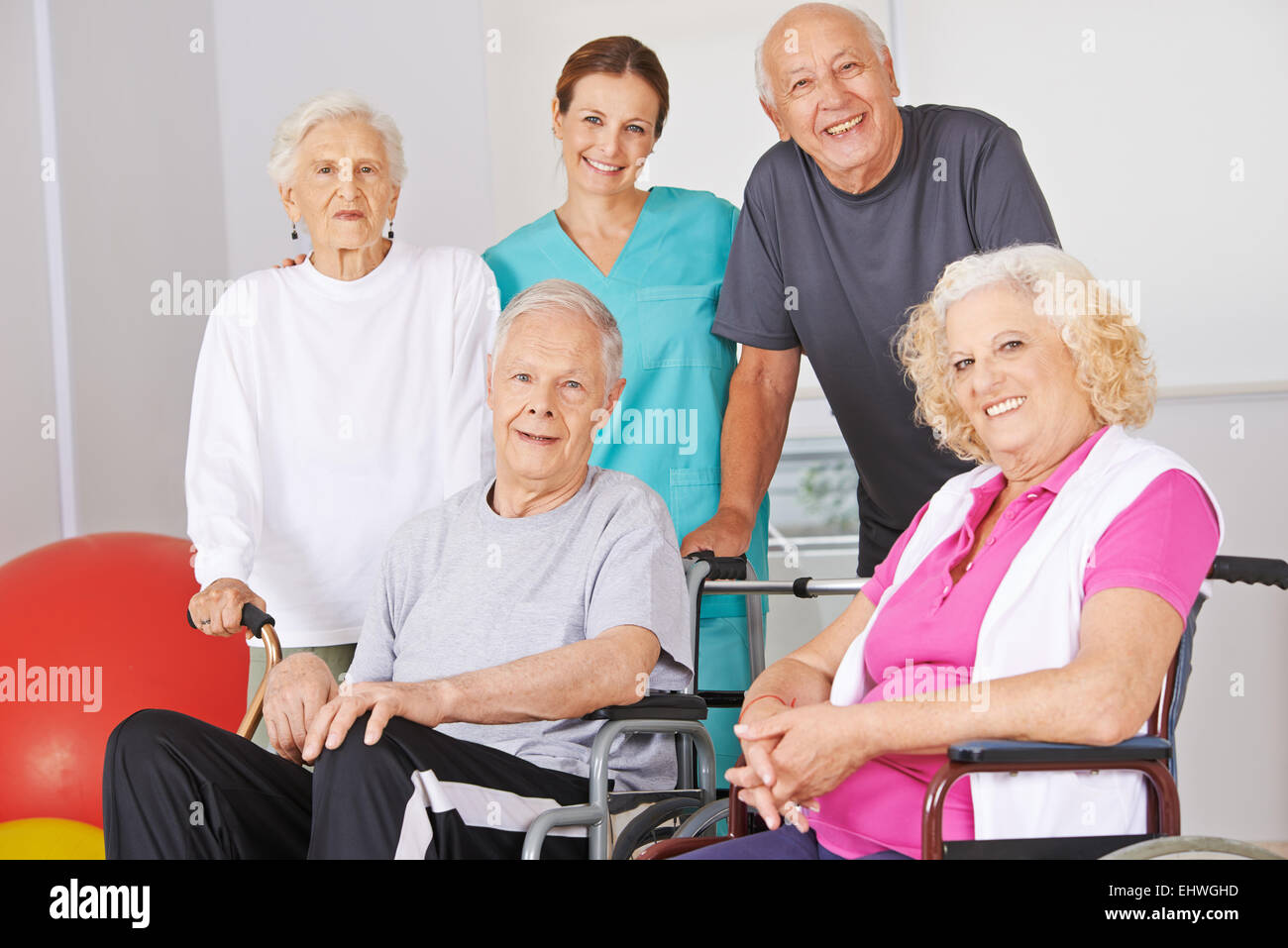 Smiling group of senior people with physiotherapist in a nursing home ...