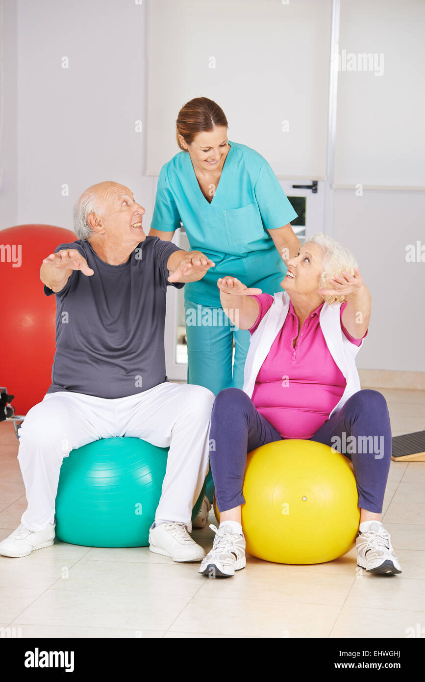 Two senior people doing fitness training in physiotherapy with ...